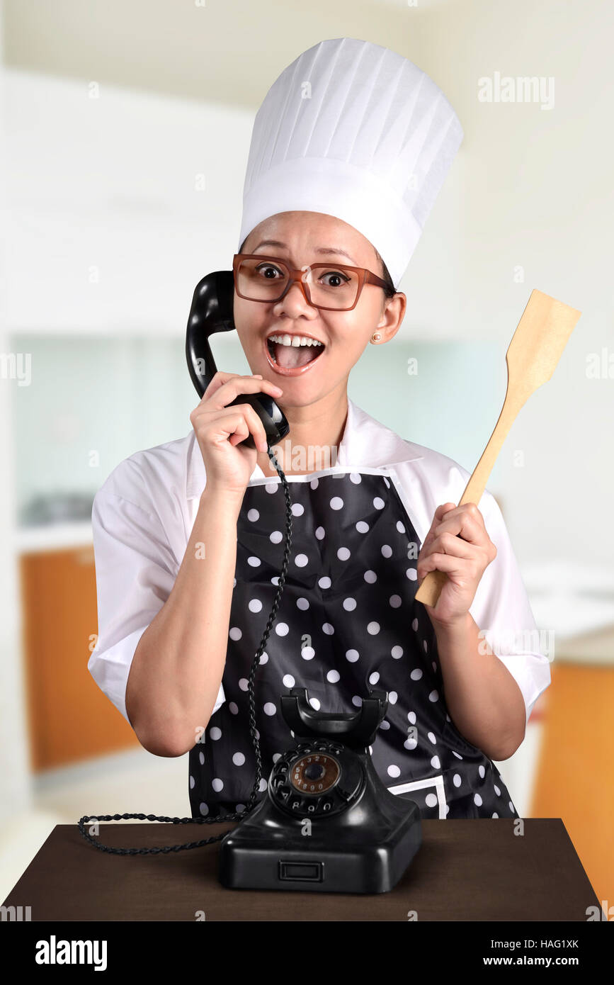 Portrait of young woman chef phone over kitchen background Stock Photo ...