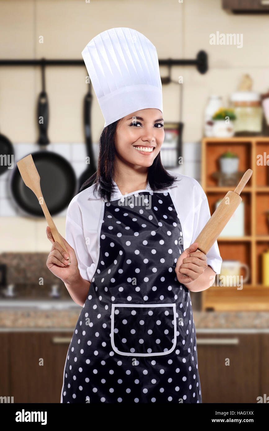 Portrait of young woman chef over kitchen background Stock Photo - Alamy