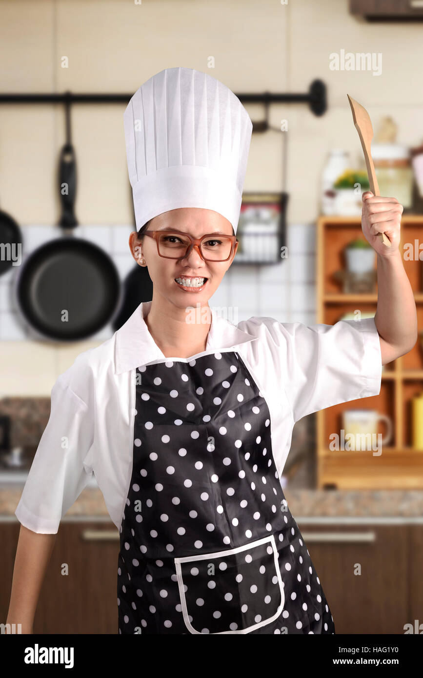 Portrait of young woman chef over kitchen background Stock Photo - Alamy