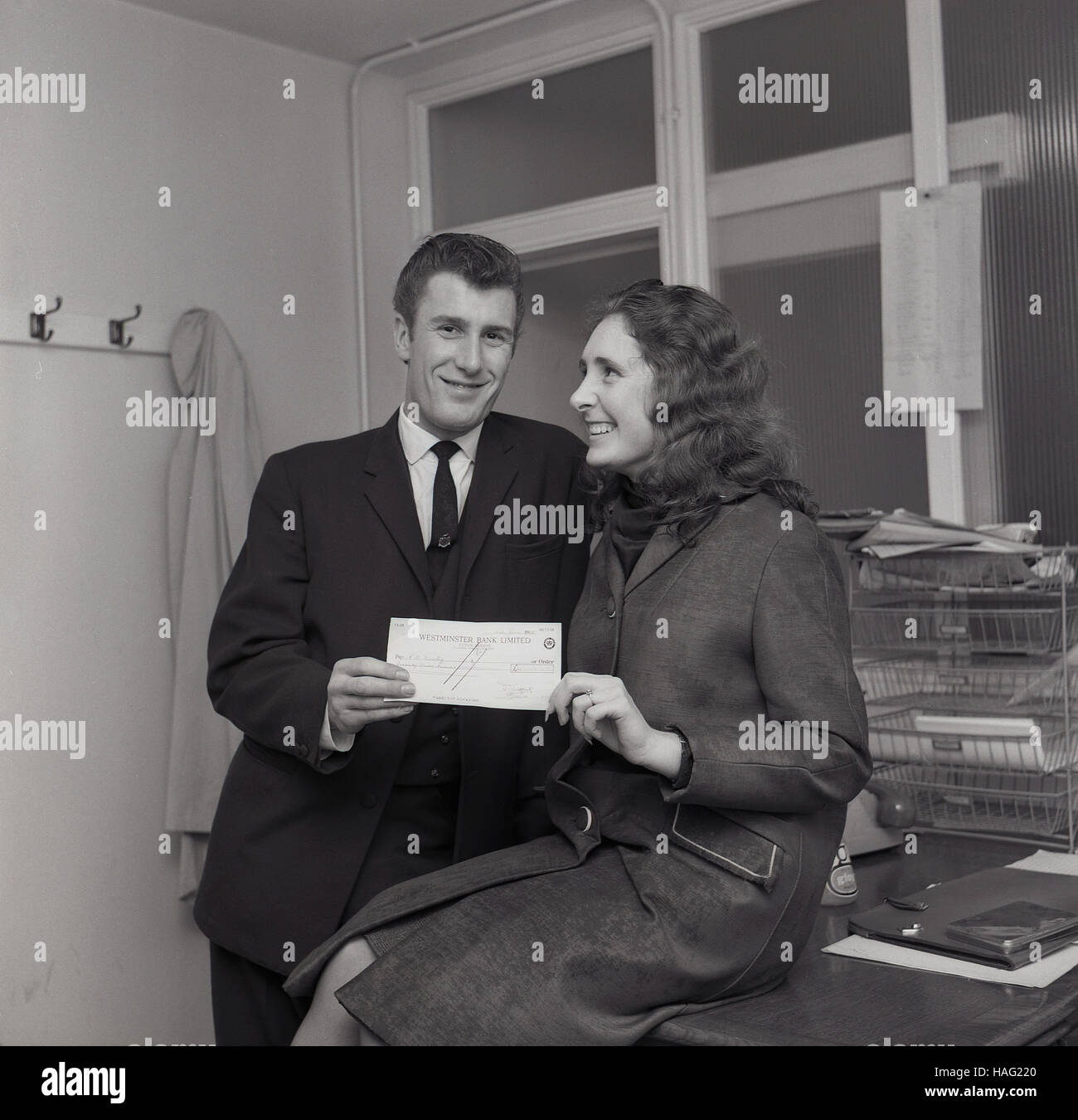 January 1965, historical, happy lady in office receiving a prize cheque ...