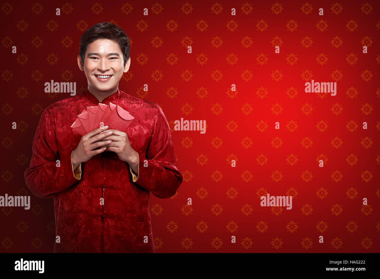 Chinese man in cheongsam suit holding angpao. Chinese new year concept ...