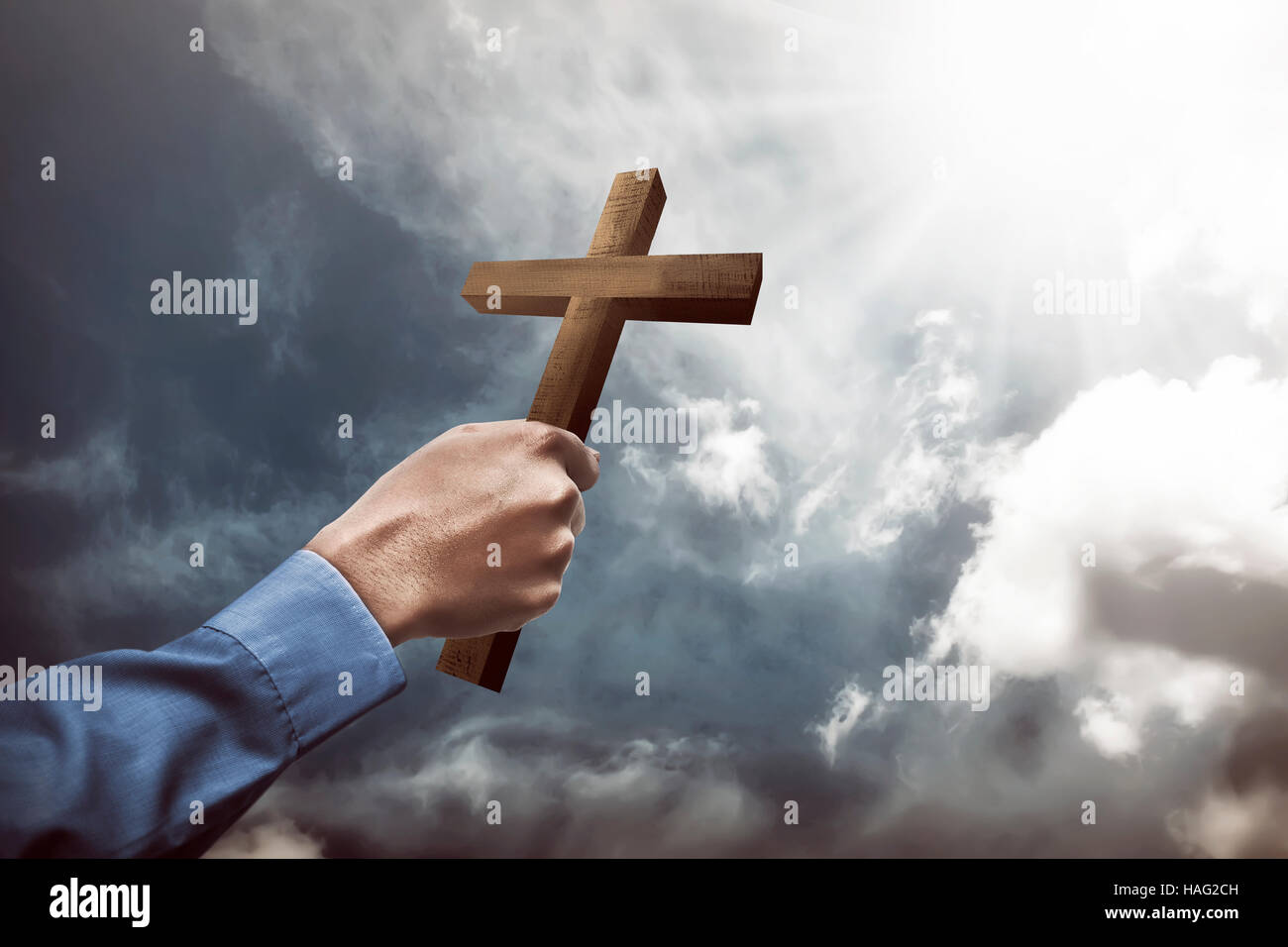 Human hand holding christian cross with sky background Stock Photo - Alamy