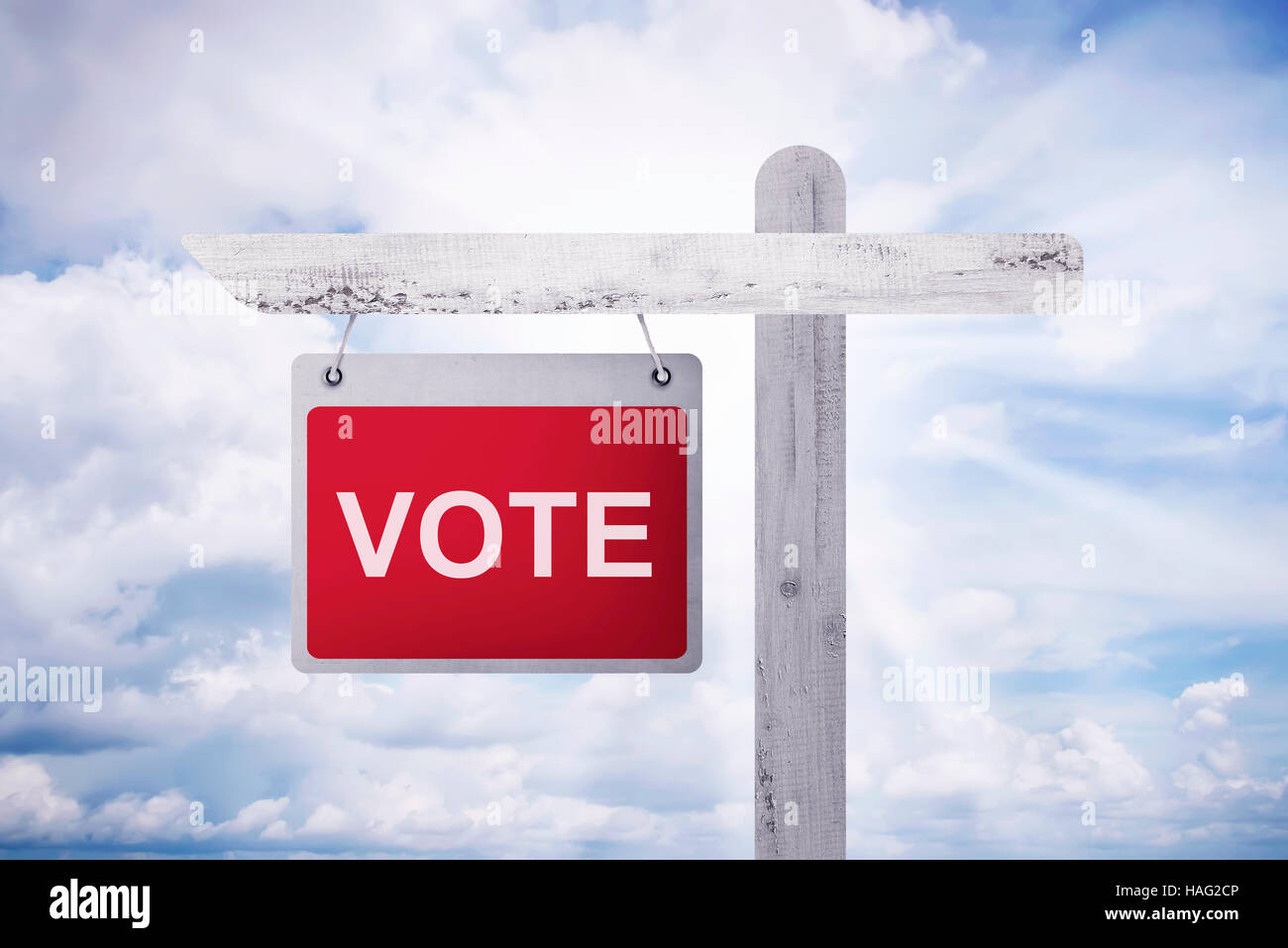 Written 'VOTE' on a red background hanging on a wooden pole with sky ...