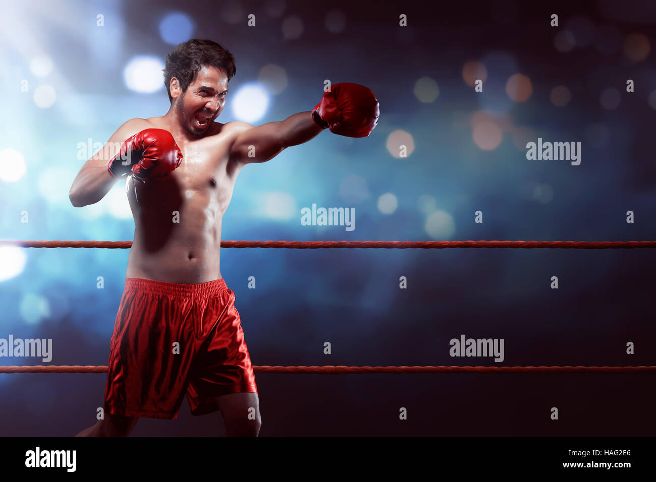 Asian boxer man doing free exercise on the ring arena before fight a ...