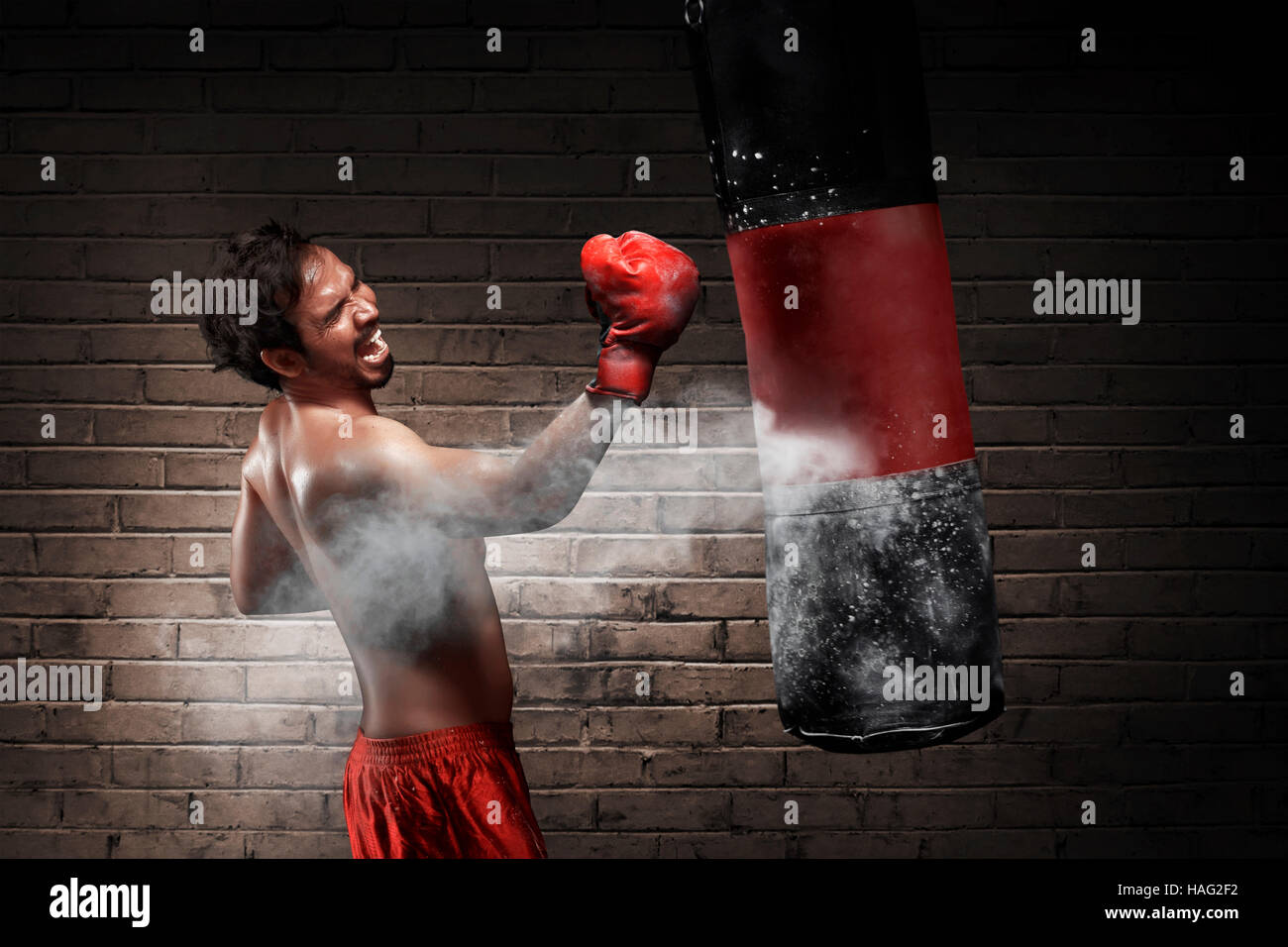 Asian male athlete boxer training uppercut with a punching bag Stock ...