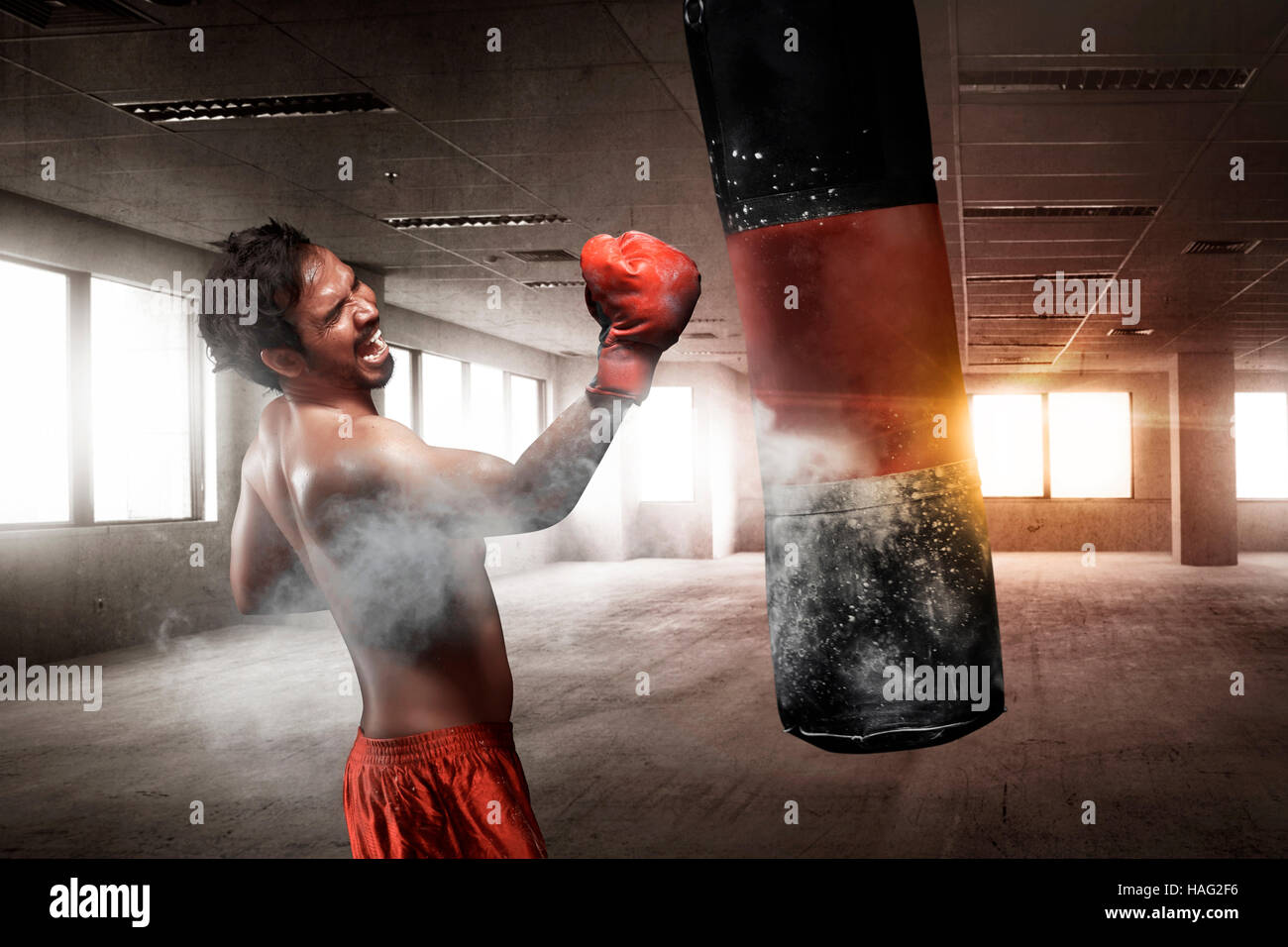 Powerful asian male boxer with punching bag for uppercut training Stock ...