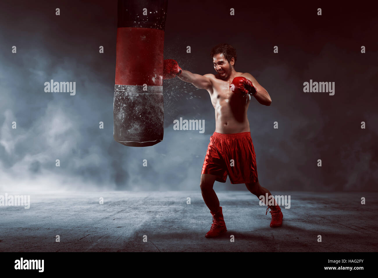 Action of asian boxer man training with punching bag on dark sports ...
