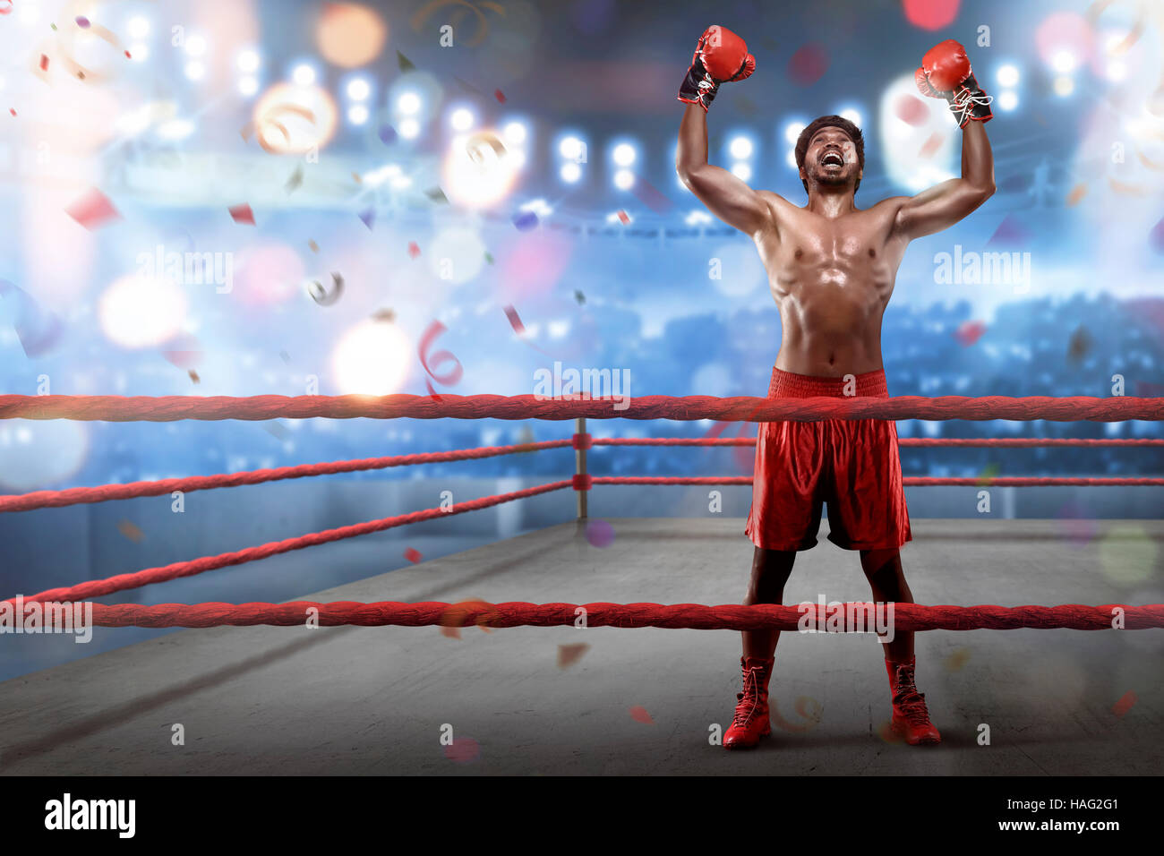 Cheerful asian young boxer is celebrating his winning in the boxing ...