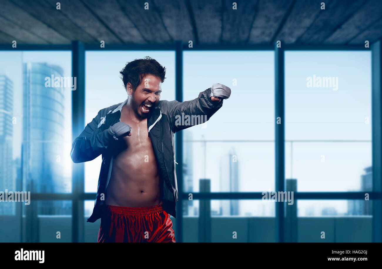 Young asian guy boxer workout in an modern gym with skyscraper view ...