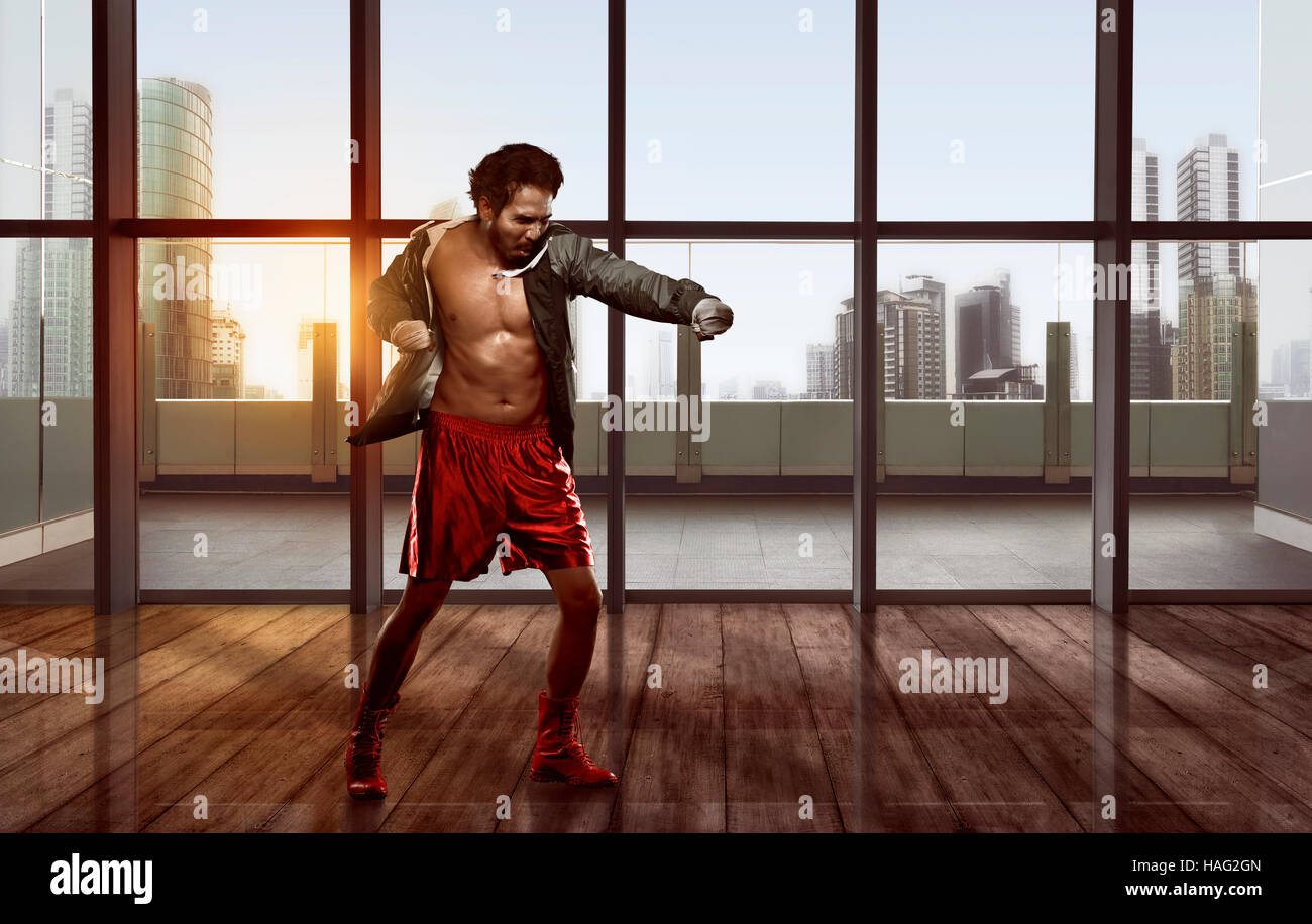 Portrait of asian man practicing boxing against skyscraper background ...