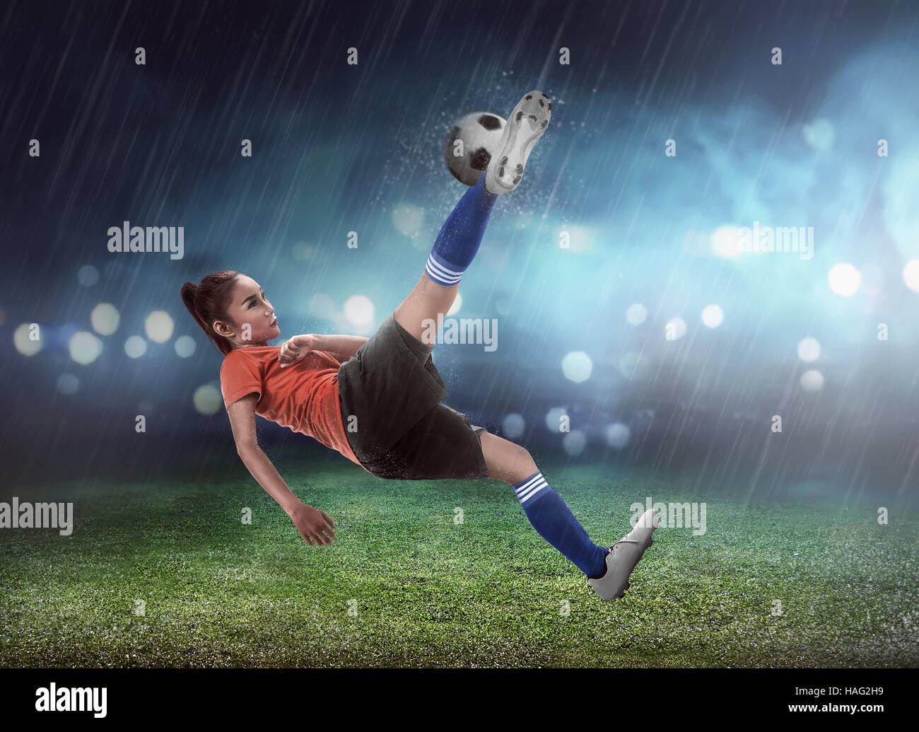 Asian woman football player kick ball on the stadium Stock Photo - Alamy
