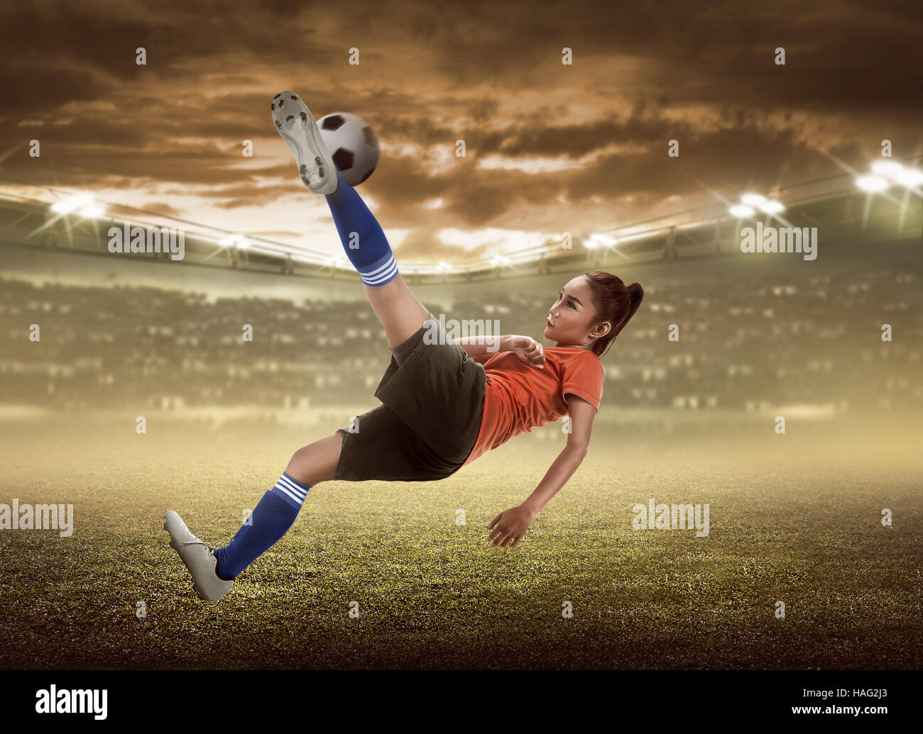 Asian woman football player kick ball on the stadium Stock Photo - Alamy
