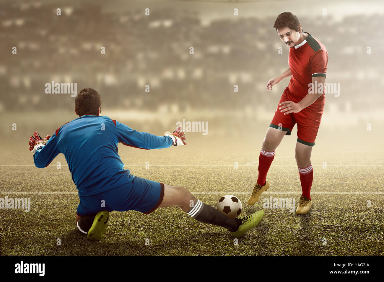 Football player kick ball and goalkeeper try to catch Stock Photo - Alamy