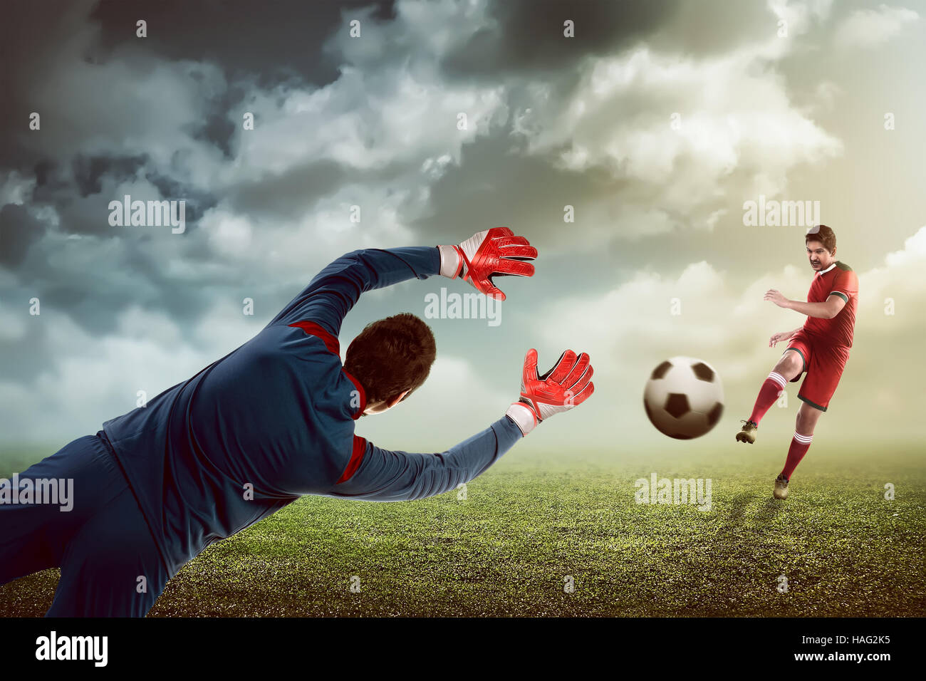 Football player kick ball and goalkeeper try to catch Stock Photo - Alamy