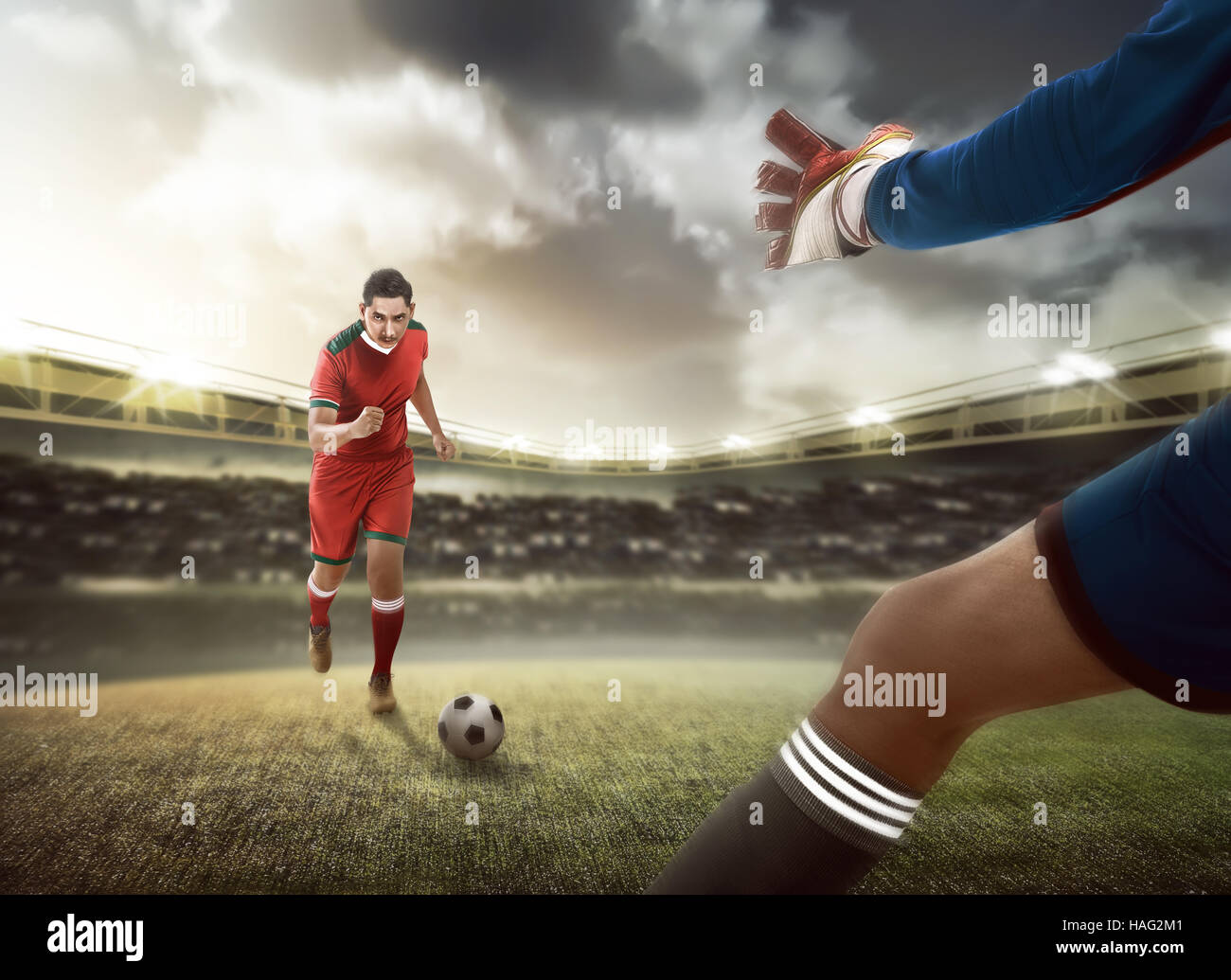 Football player kick ball and goalkeeper try to catch Stock Photo - Alamy