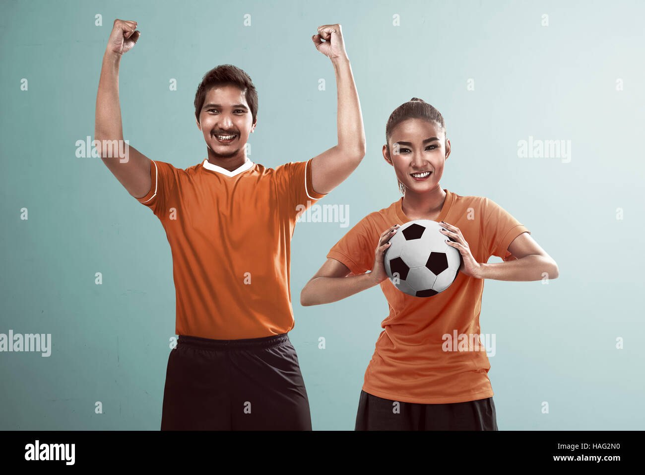 Happy couple football fan holding ball and cheering their team Stock ...