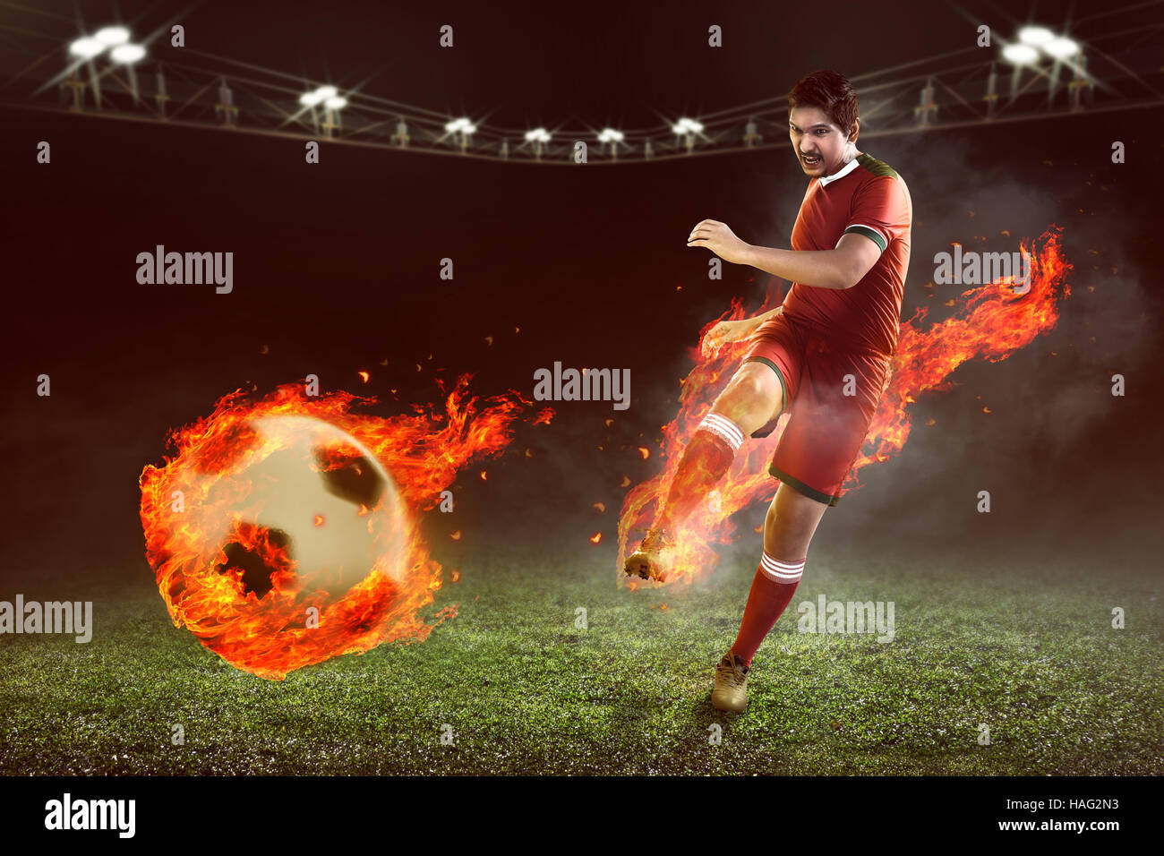 Asian football player kick fire ball on the stadium Stock Photo - Alamy