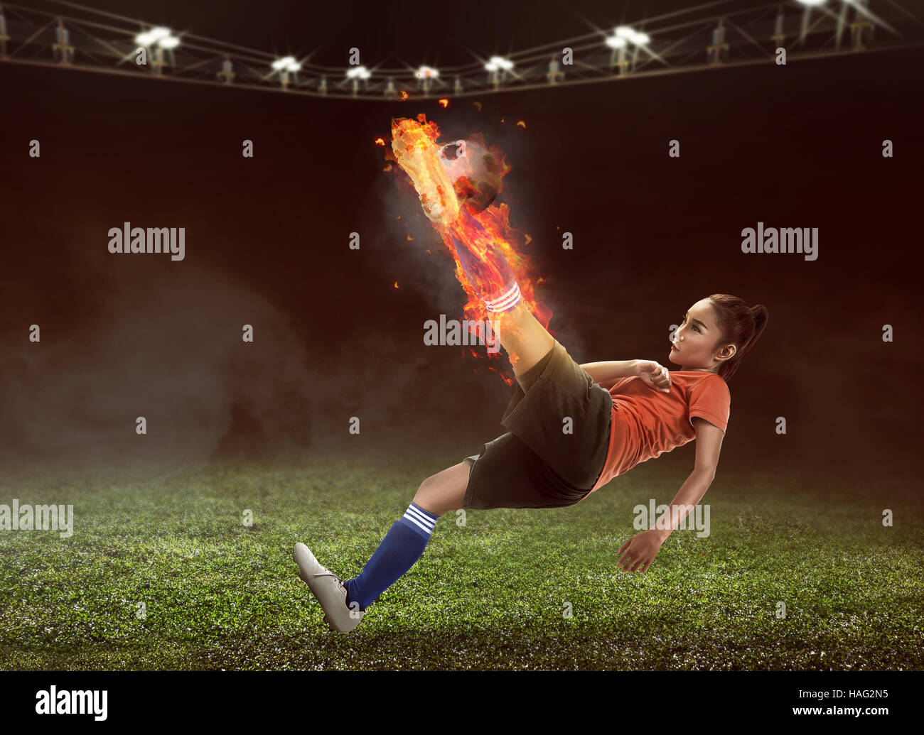 Asian woman football player kick fire ball on the stadium Stock Photo ...