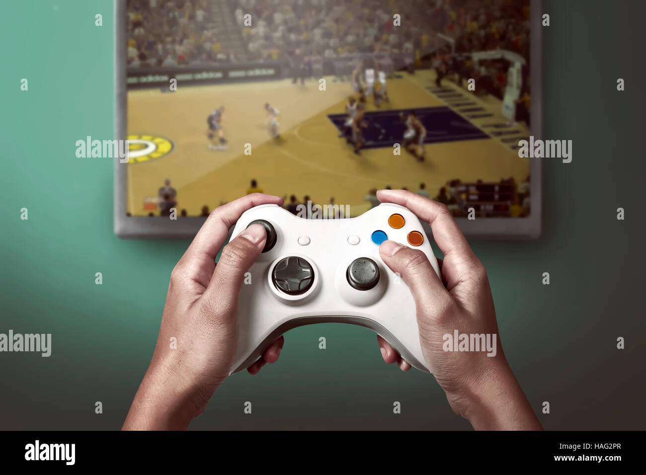 Hand holding game console controller playing sport game on the ...