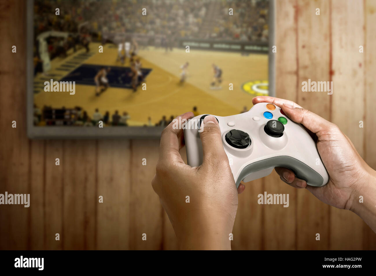 Hand holding game console controller playing sport game on the ...