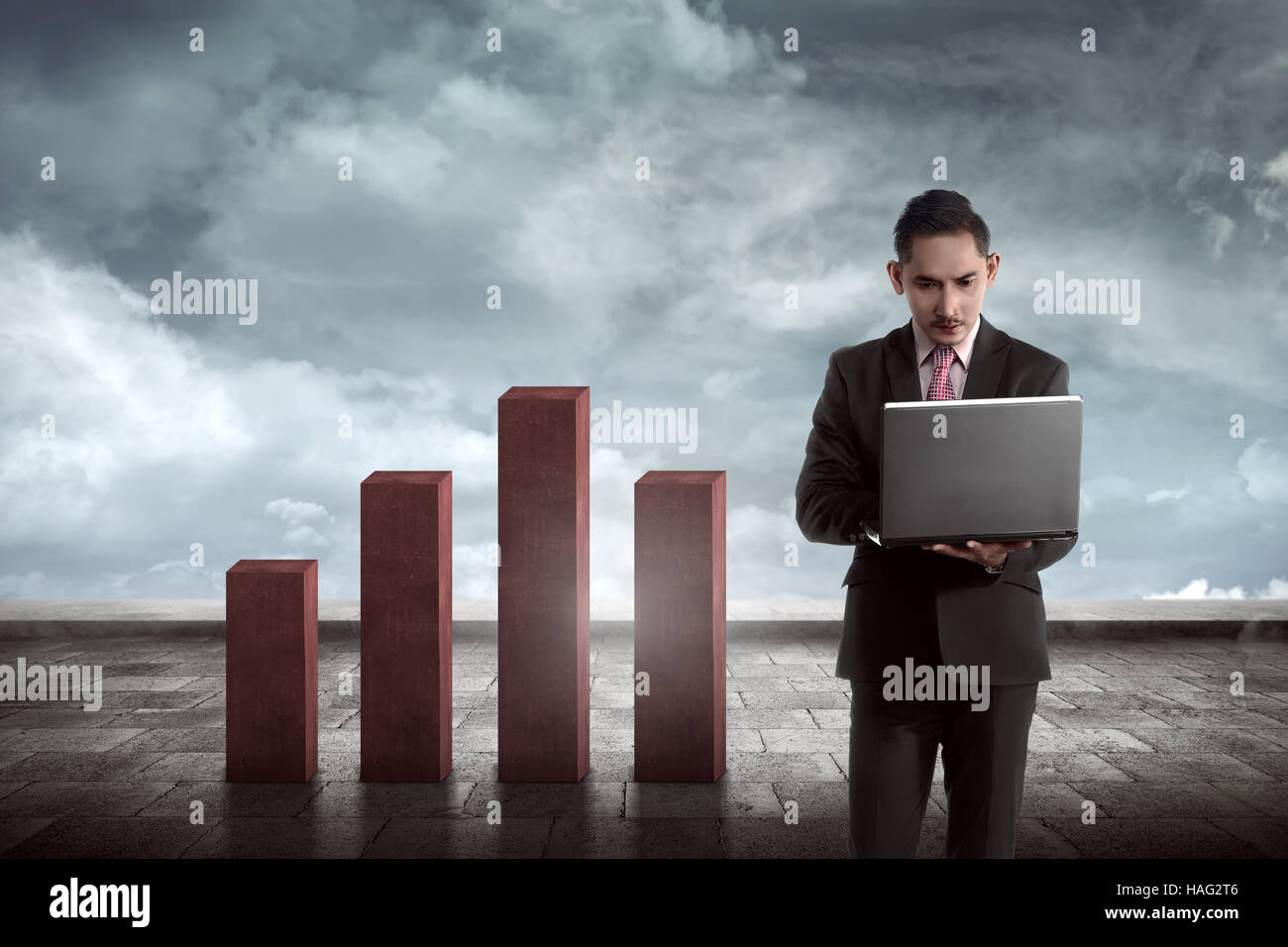 Asian business man typing on laptop with increase chart background ...