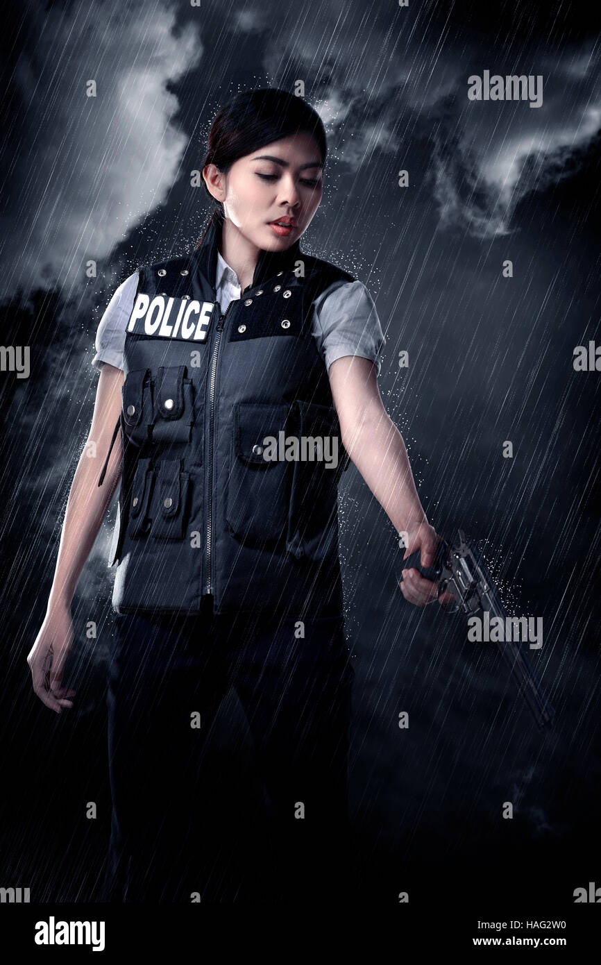 Beautiful police woman holding gun ready to fire Stock Photo - Alamy
