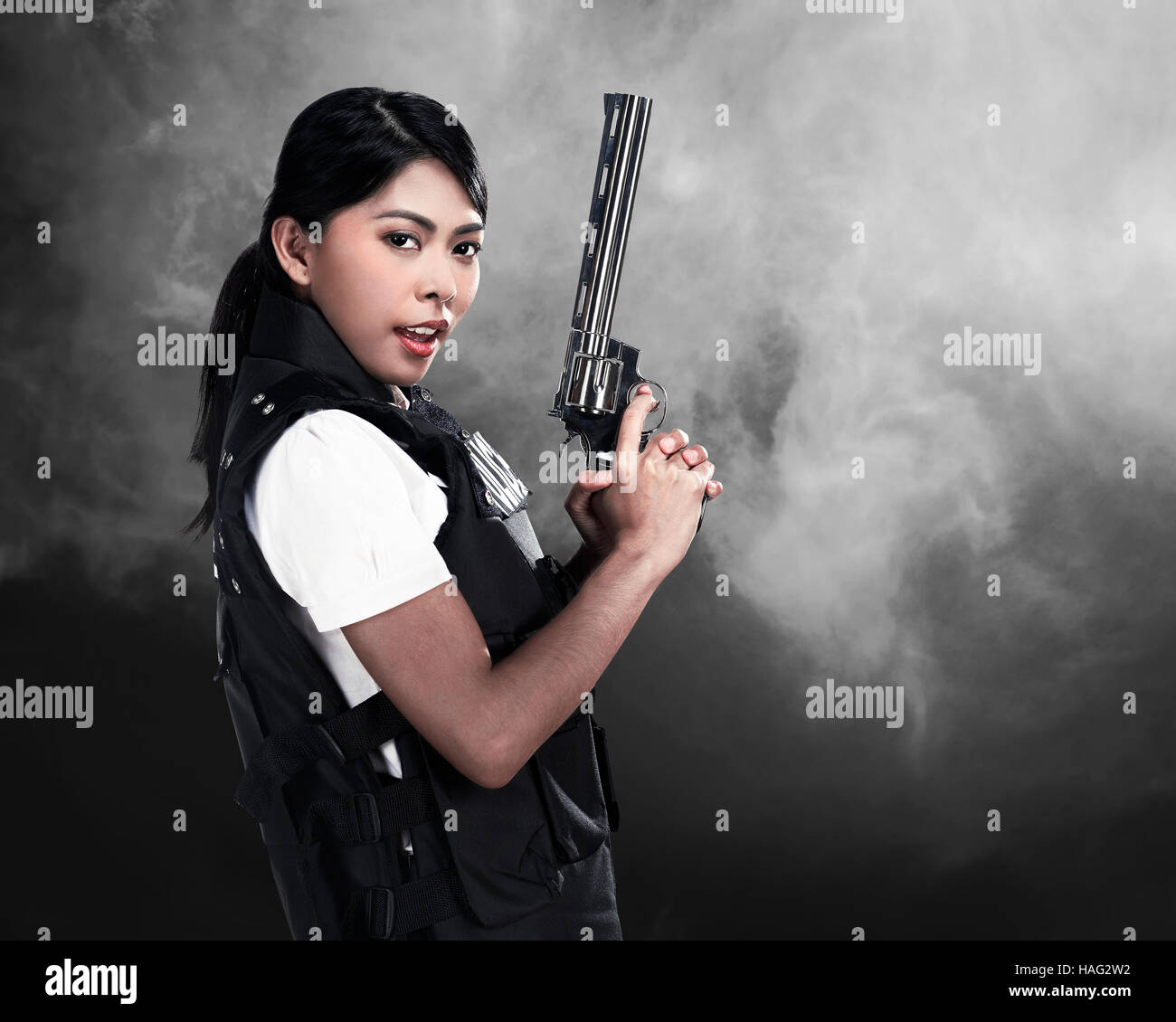 Beautiful police woman holding gun ready to fire Stock Photo - Alamy