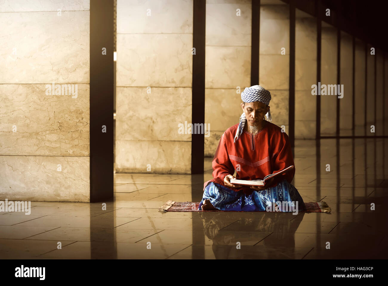 Religious muslim man reading holy koran inside the mosque Stock Photo ...