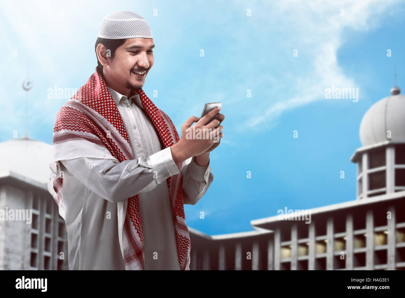 Muslim man holding cellphone and typing on the phone Stock Photo - Alamy