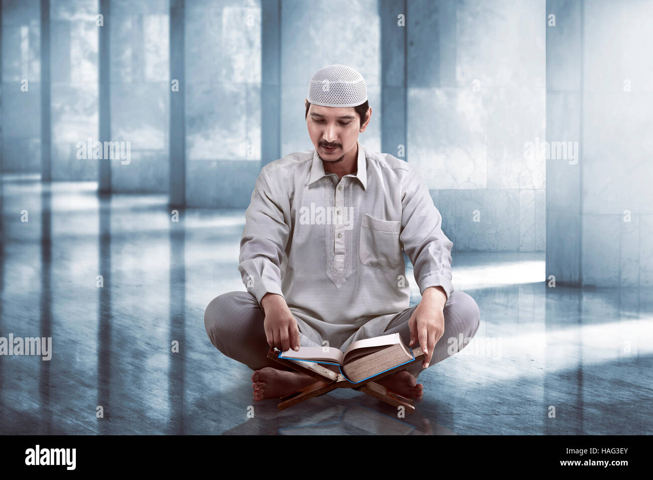Young asian muslim people reading koran on the mosque Stock Photo - Alamy