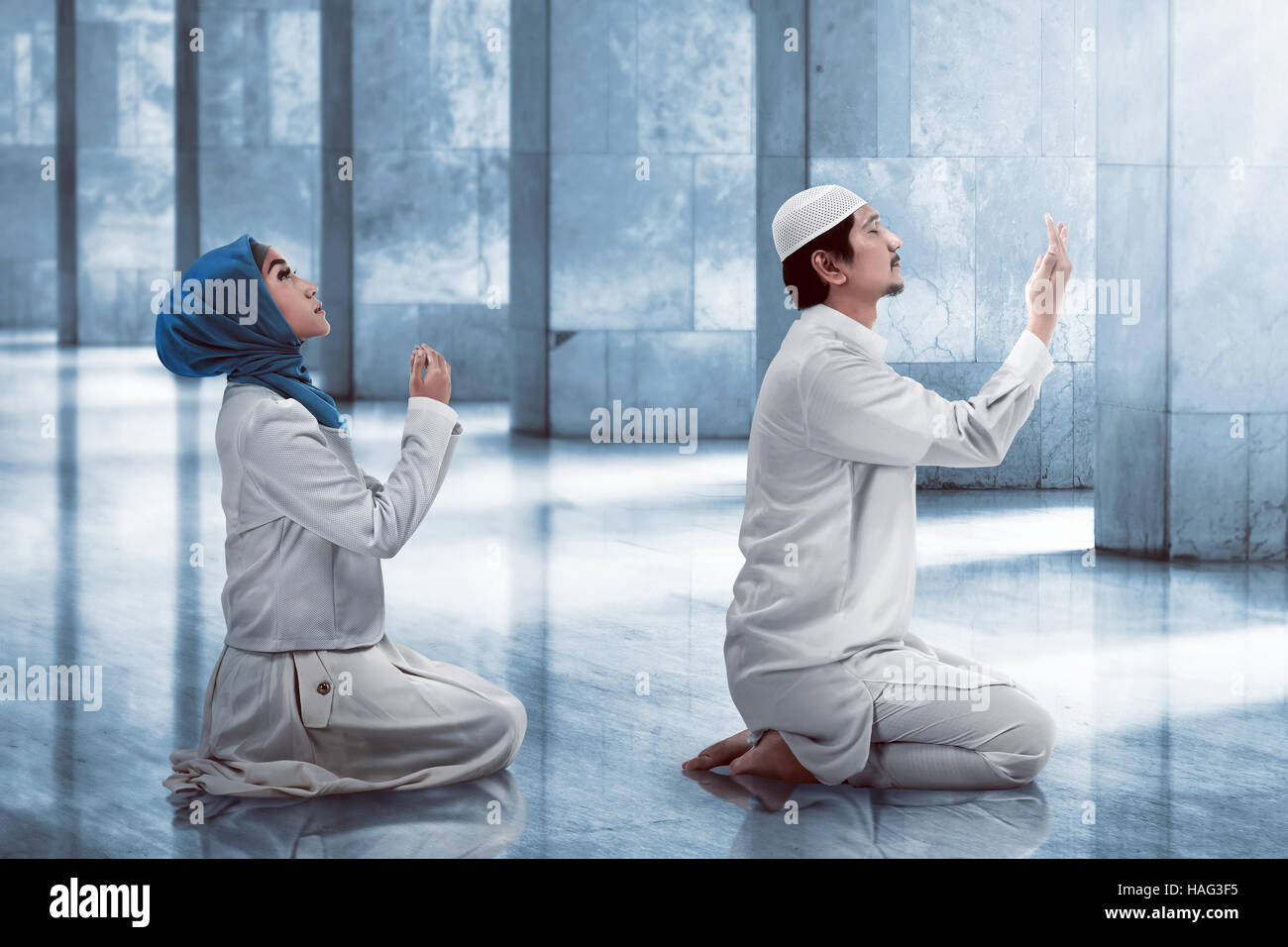 Young muslim couple praying inside the mosque Stock Photo - Alamy