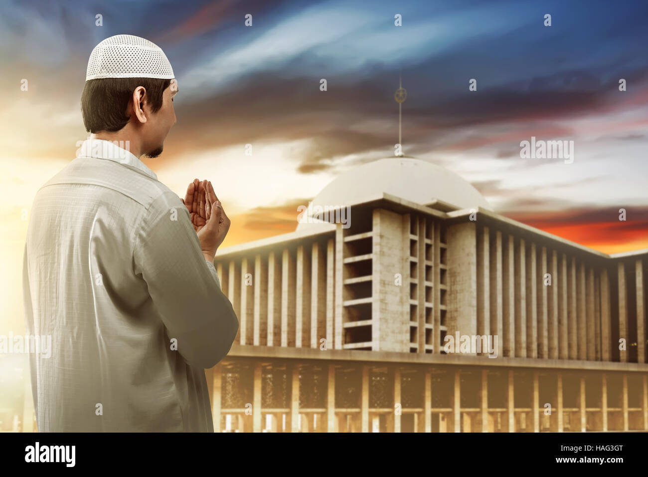 Back view of young muslim man praying looking to mosque Stock Photo - Alamy