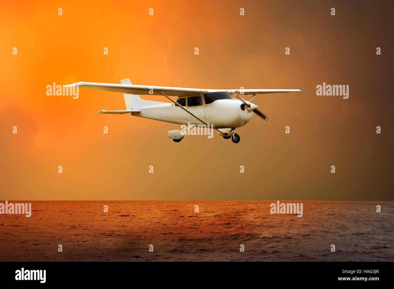 Propeller plane flying over the ocean when sunset Stock Photo - Alamy