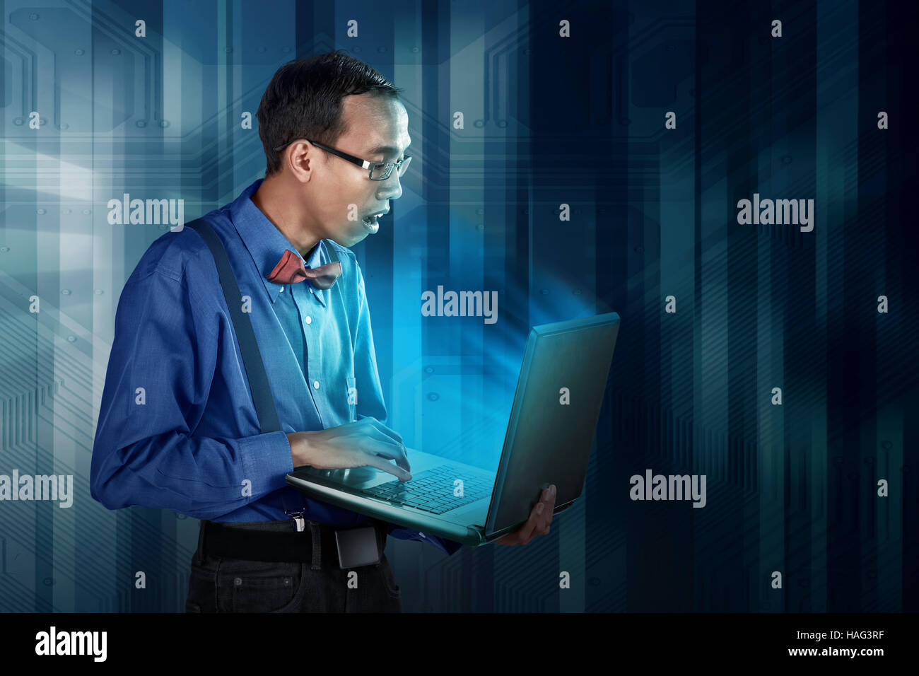 Nerdy man using laptop with gawk face expression, wearing formal shirt ...