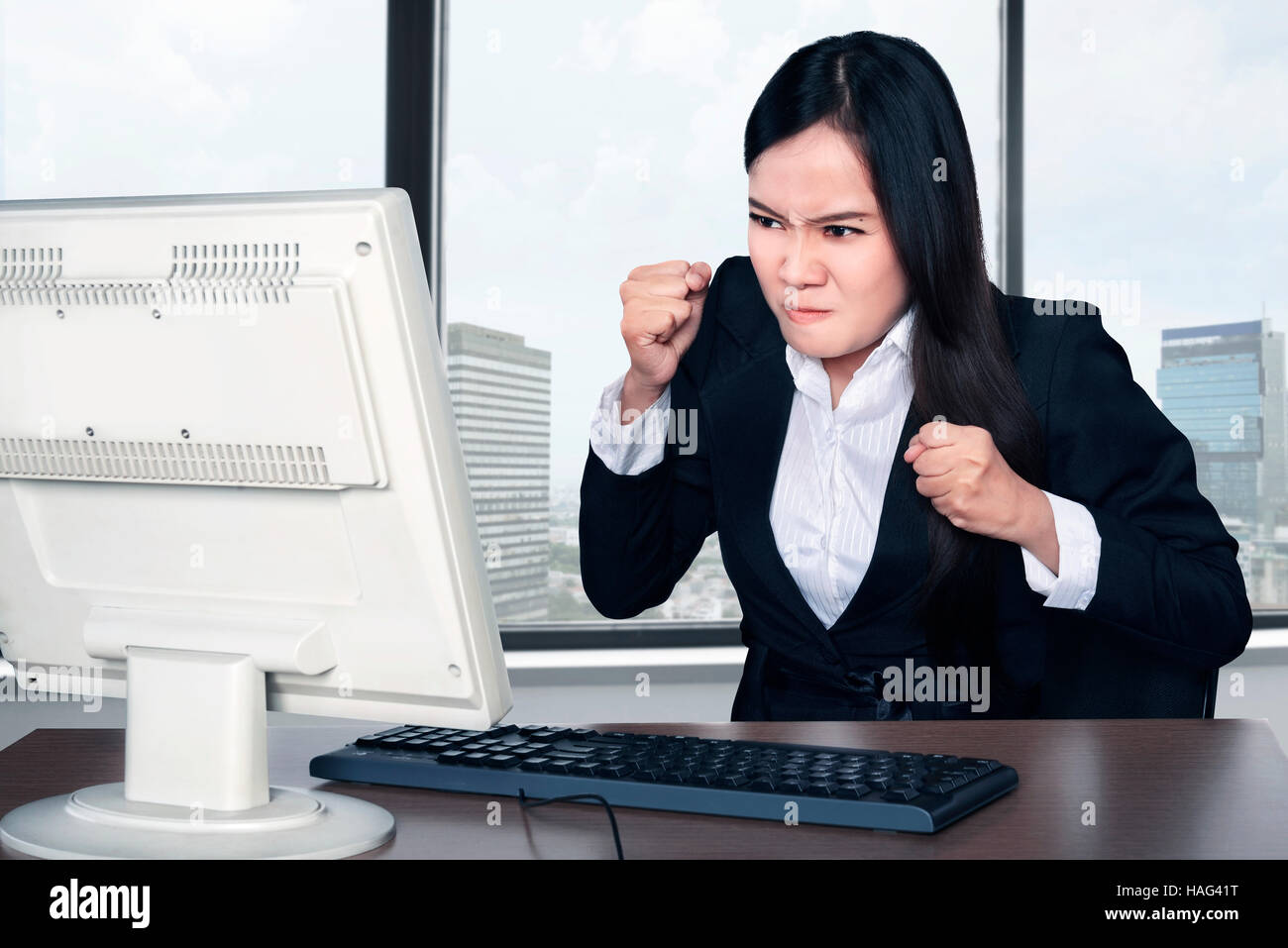 Smiling happy woman using computer with office background Stock Photo ...