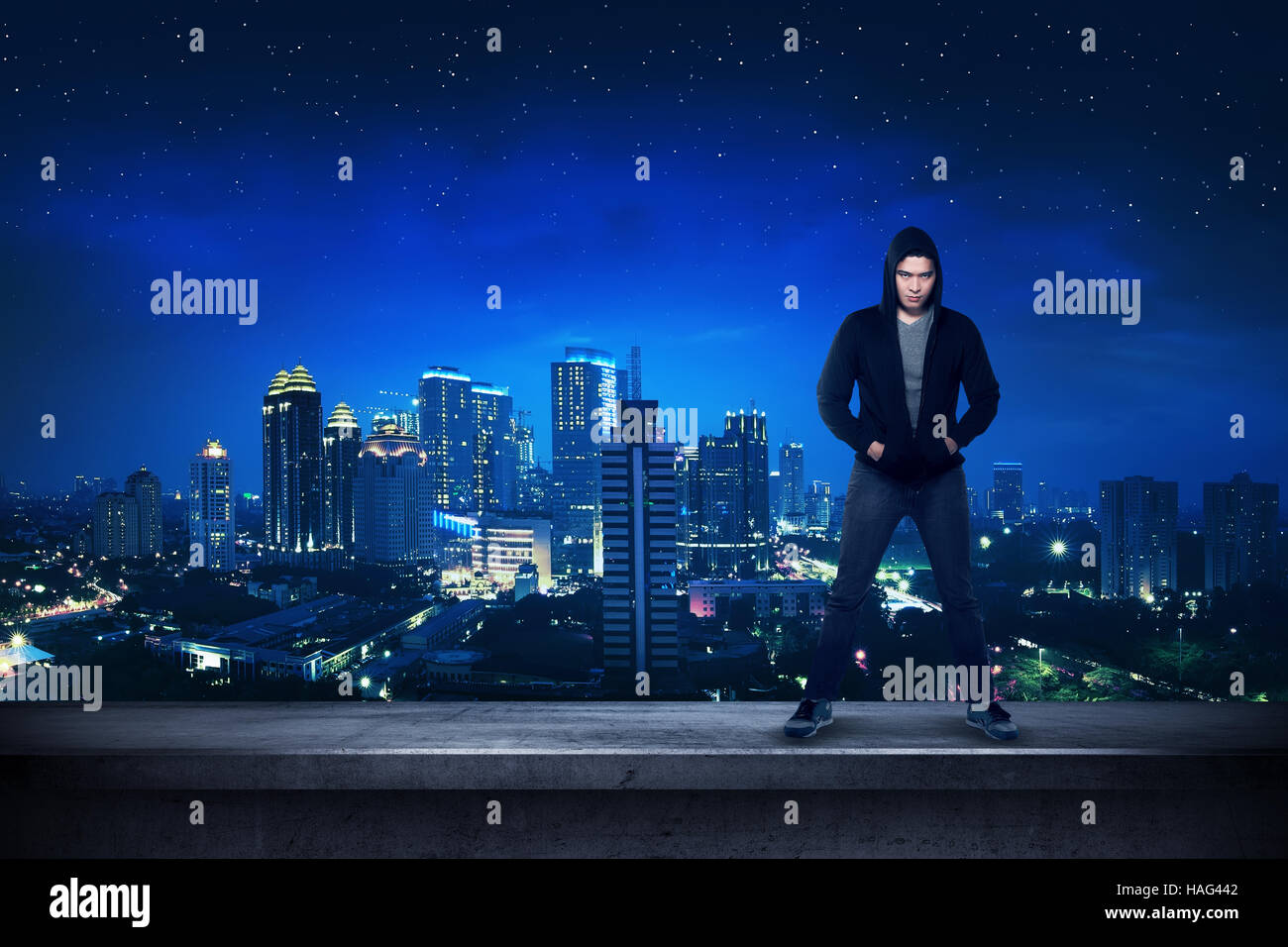 Bad guy standing on the building rooftop with city background Stock ...