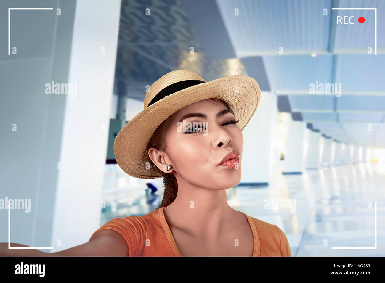 Young asian woman pose selfie in airport lobby with duckface expression ...