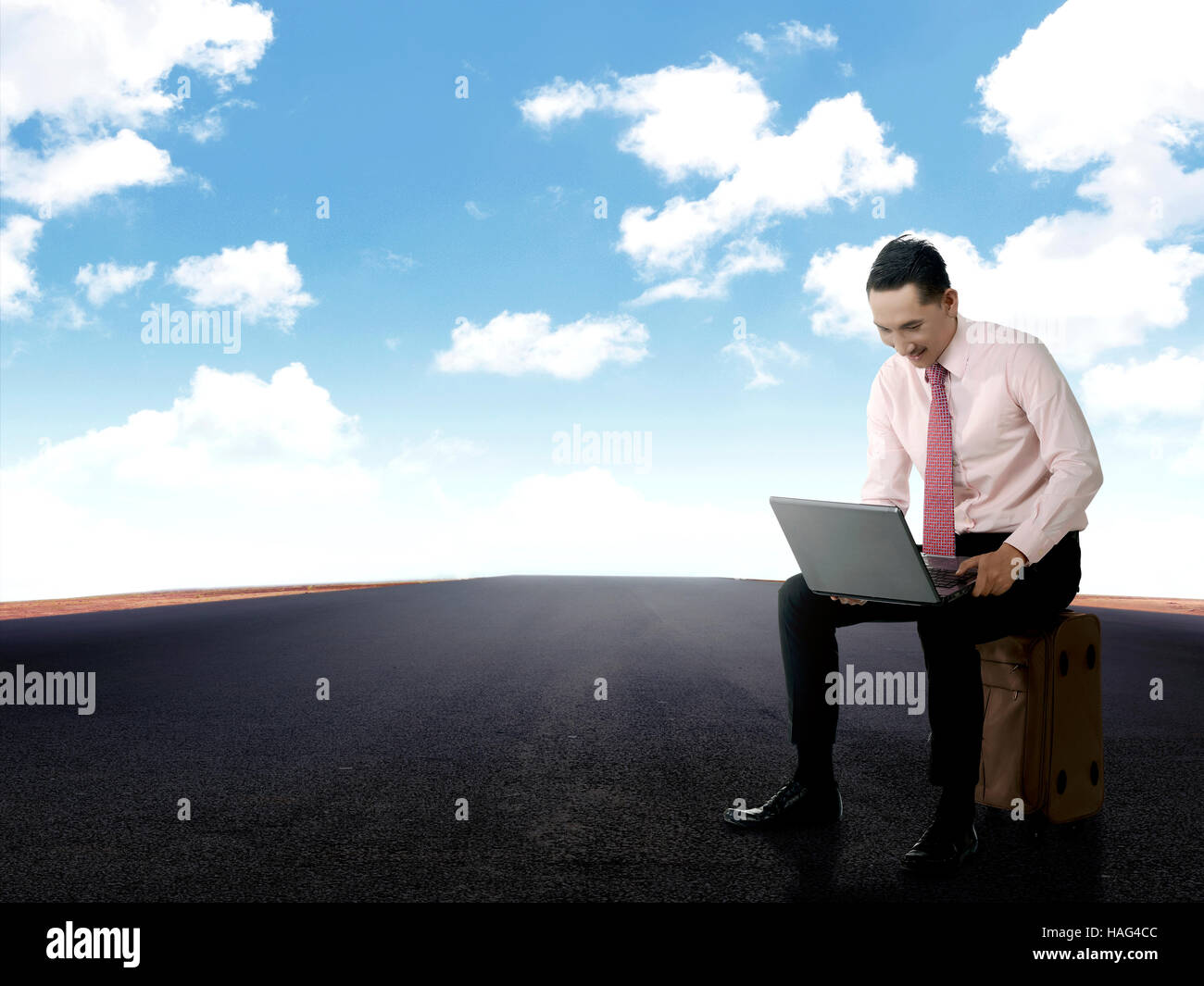 Business man working with laptop on empty road. Mobile worker ...
