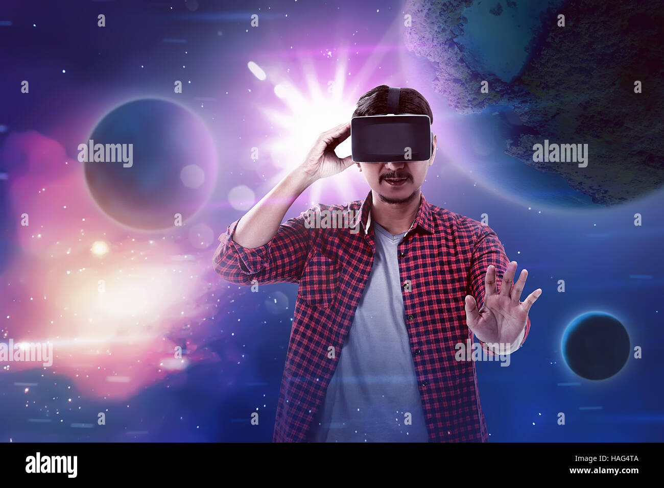 Young asian man wear VR headset get into virtual reality world. Virtual ...