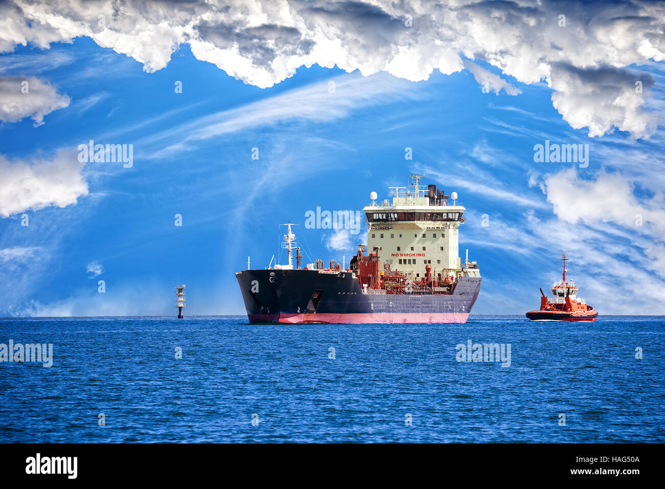 Tug boat towing a tanker ship at sea Stock Photo - Alamy