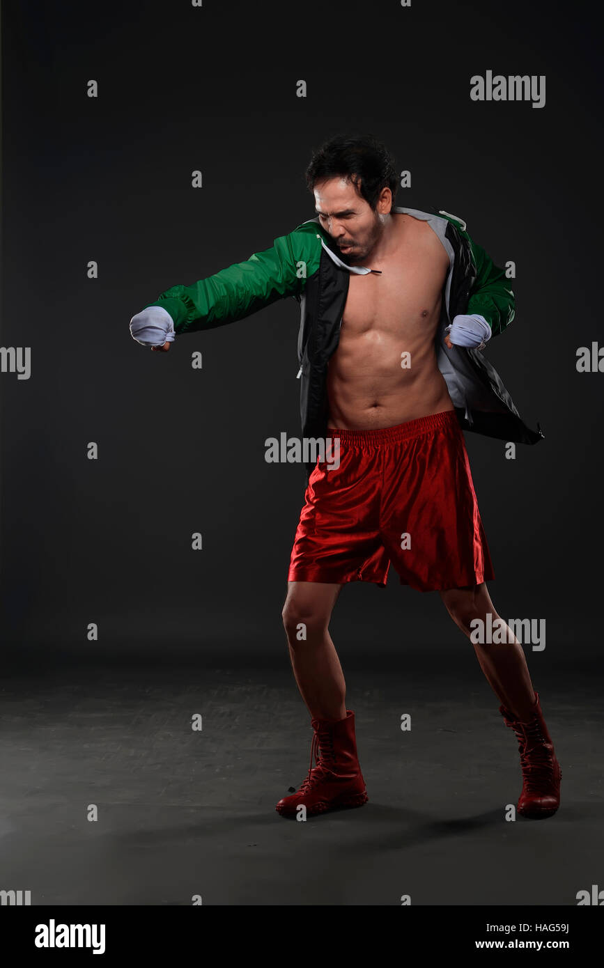 Portrait of asian male boxer practicing boxing over black background ...