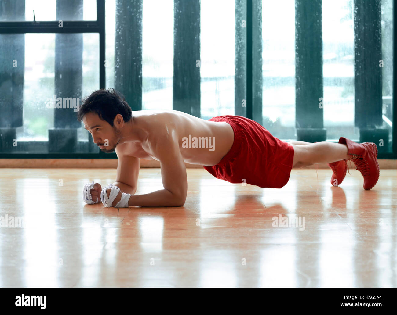 Muscular and strong asian guy doing plank exercise in the studio Stock ...