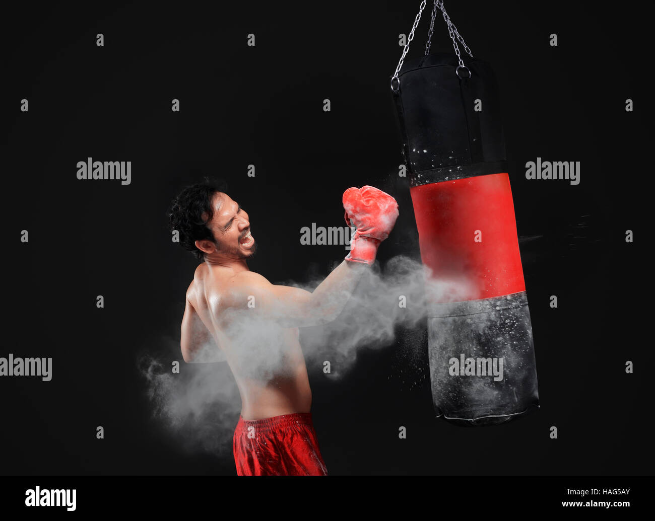 Masculine asian boxer punching the punching bag with very strong Stock ...