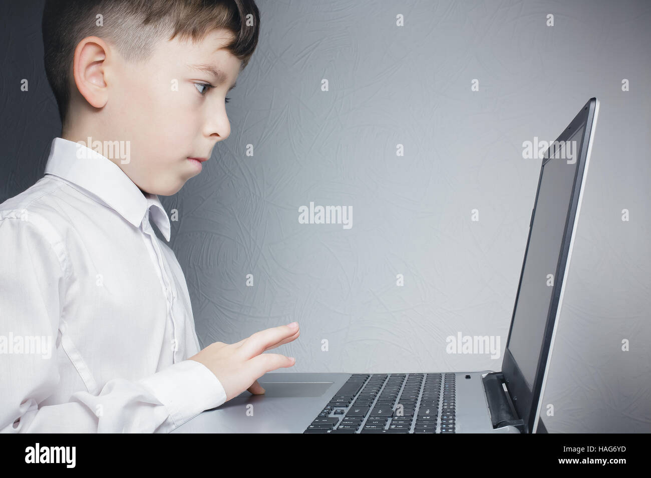 School child looking at computer over gray background Stock Photo - Alamy