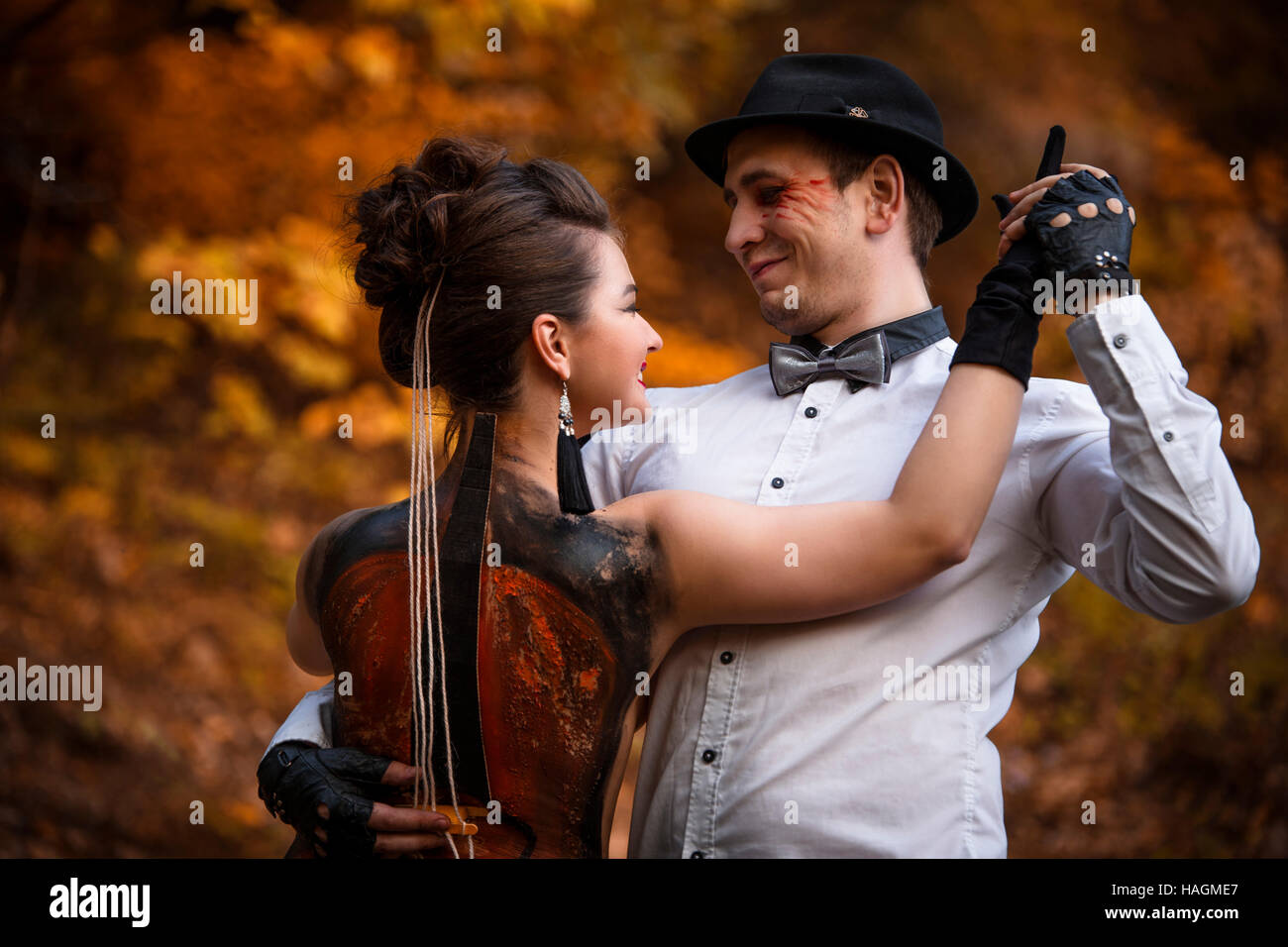 Young man imitating music performance on woman's back with painted ...