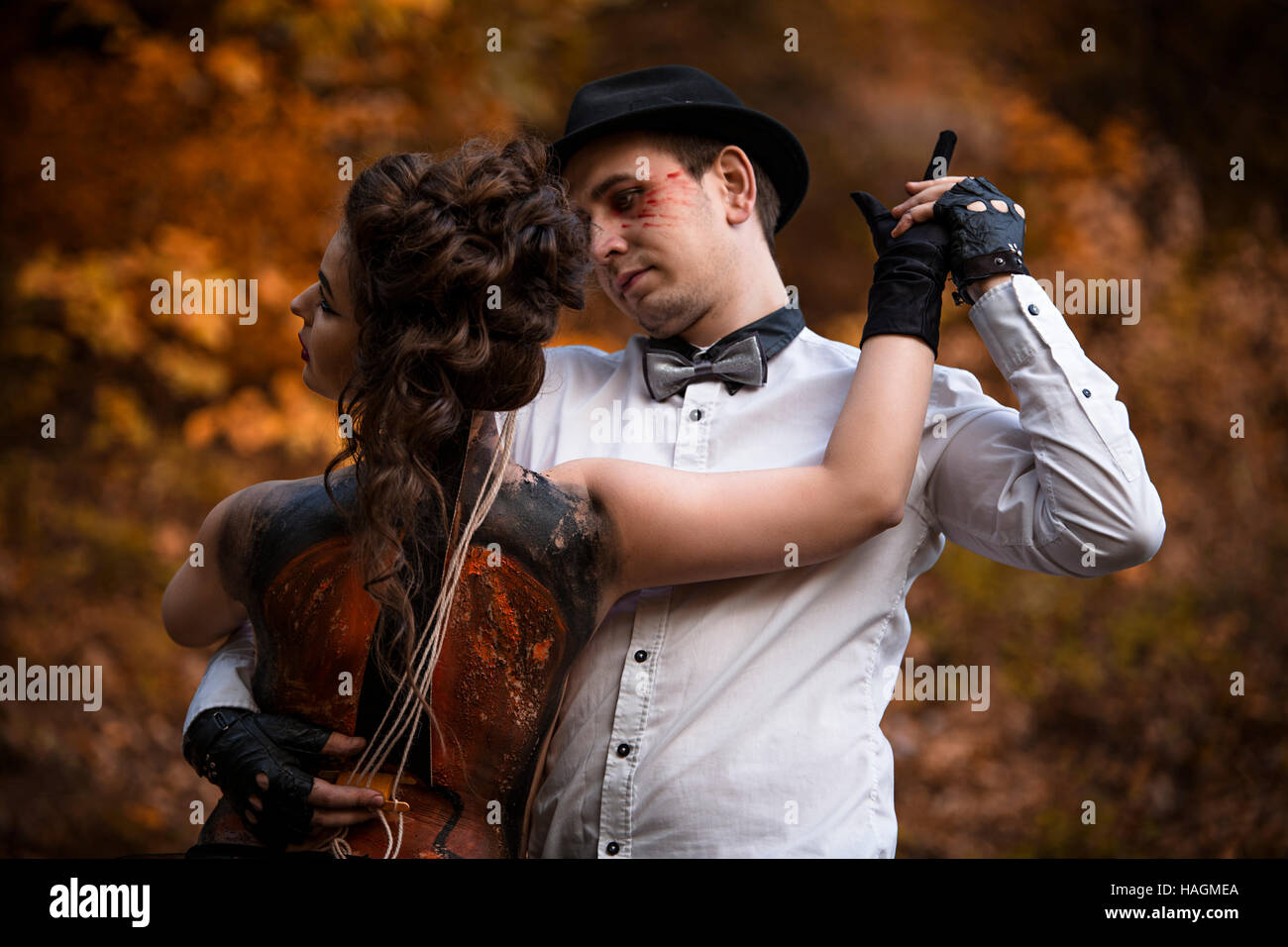 Young man imitating music performance on woman's back with painted ...