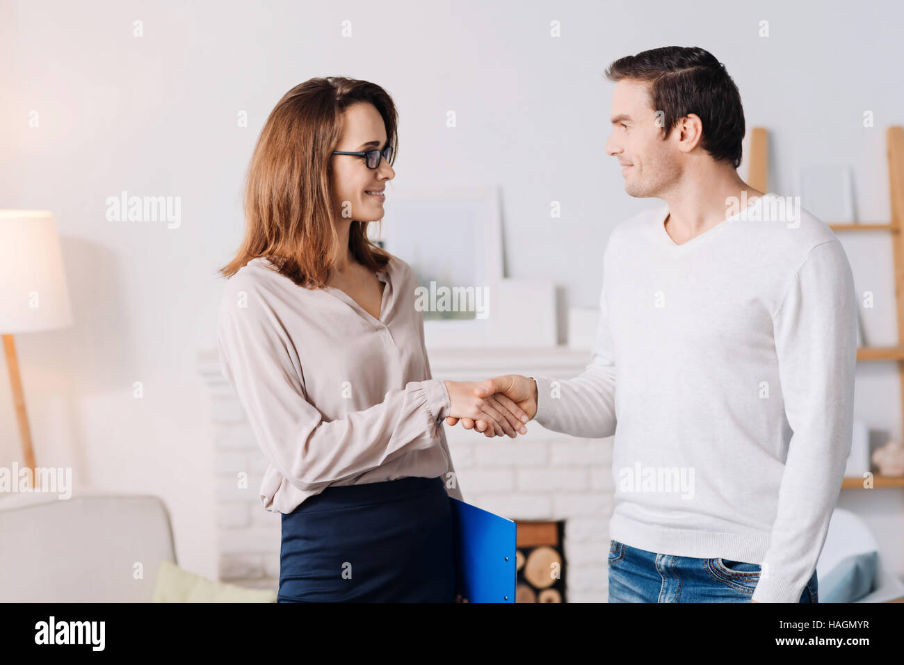 Positive female psychologist shaking hands with her client Stock Photo ...