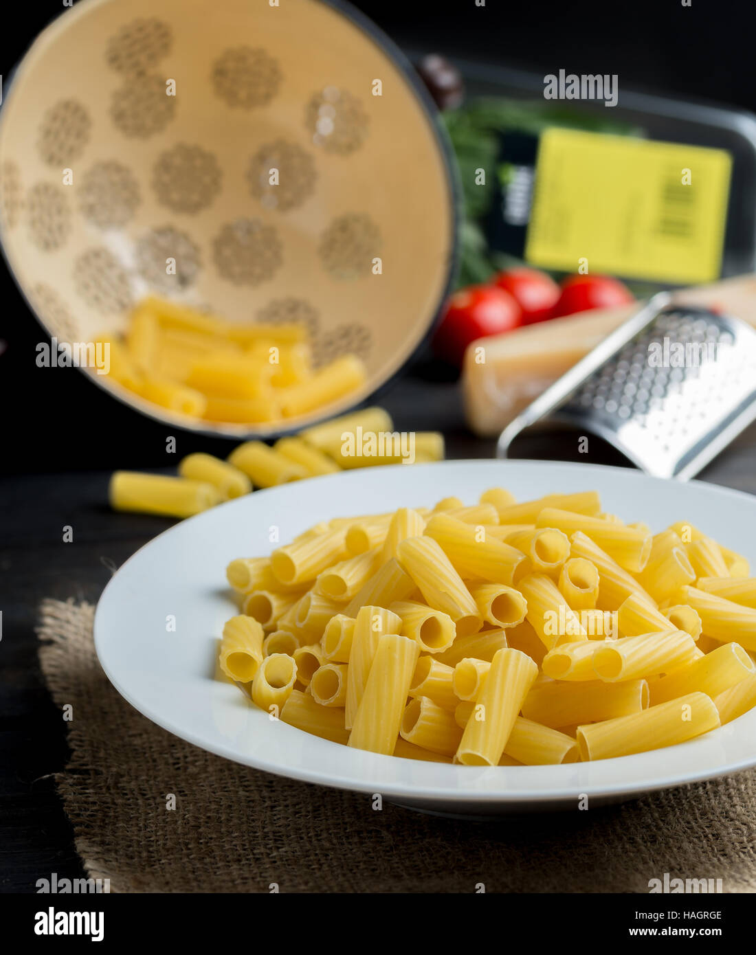 Raw pasta in white plate on natural wooden table Stock Photo - Alamy