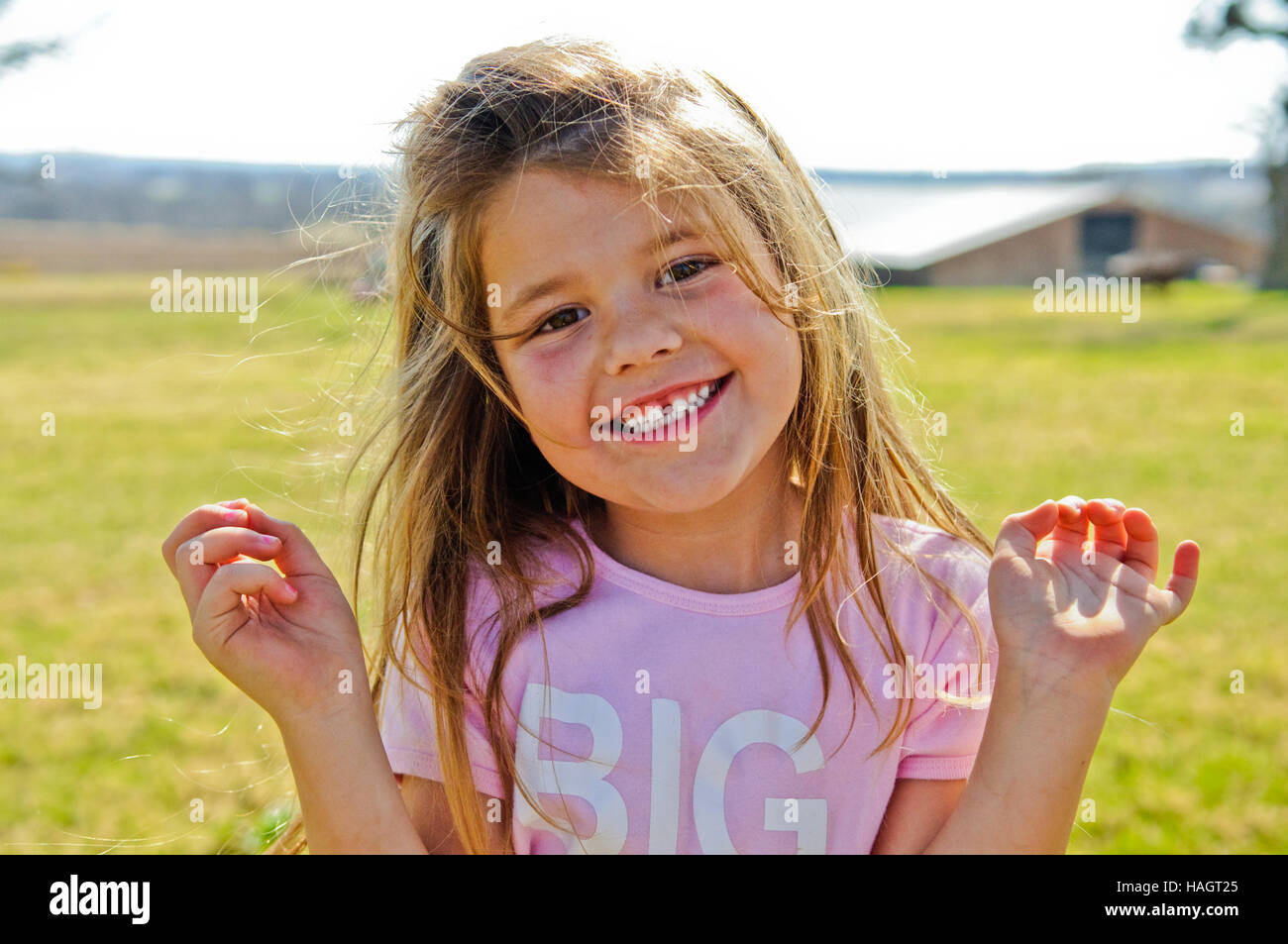 Happy retty little girl outside with barn in background Stock Photo - Alamy