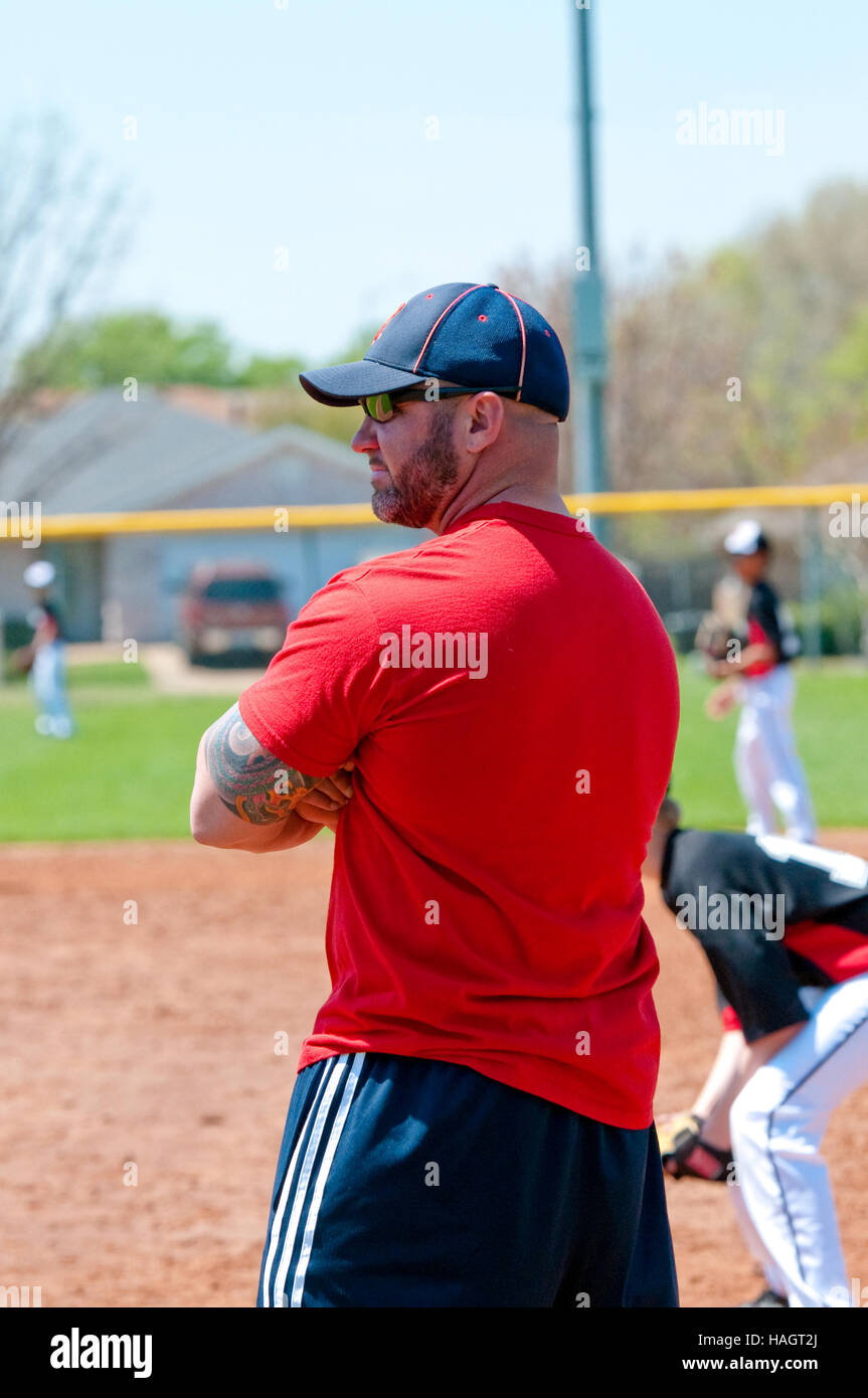 Muscular and handsome baseball coach at first base line looking at ...